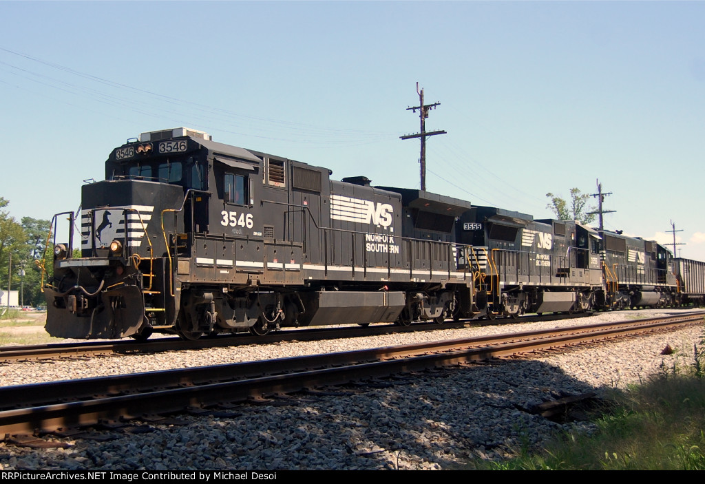 NS B32-8 # 3546 leads an empty westbound hopper train across Main St.
